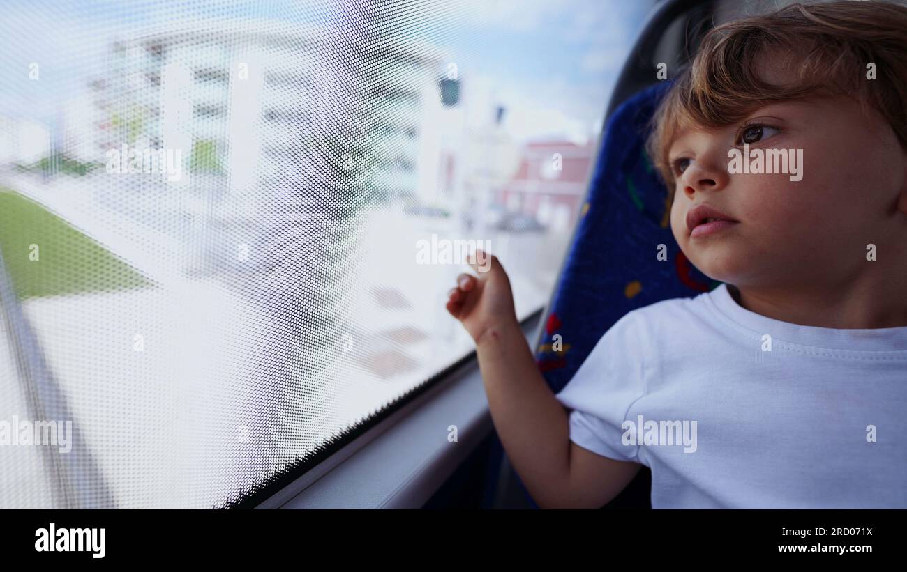 Child looking through bus window pointing city passenger kid on public ...