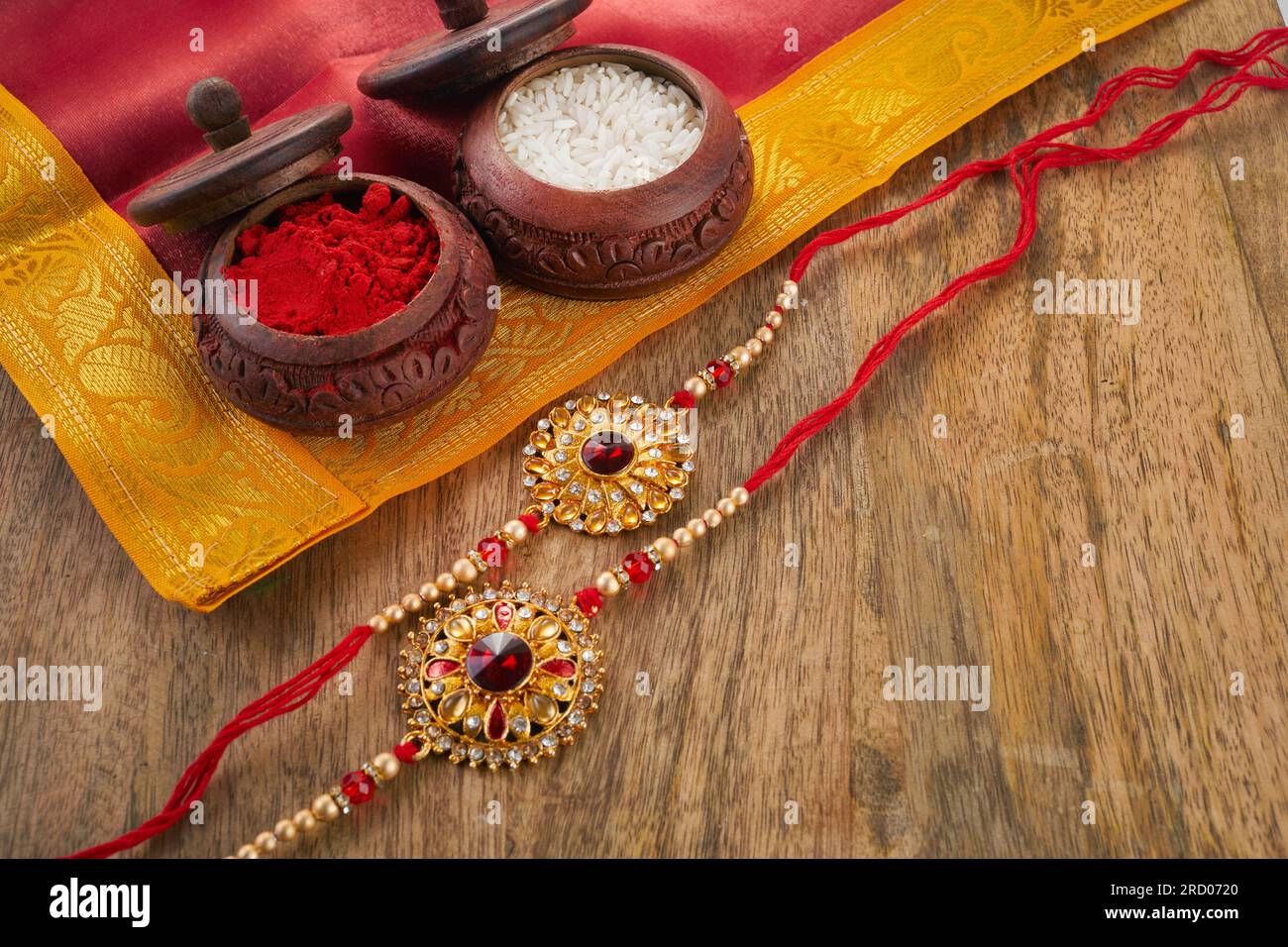 Raksha Bandhan background with Rakhi string, Rice Grains and Kumkum ...