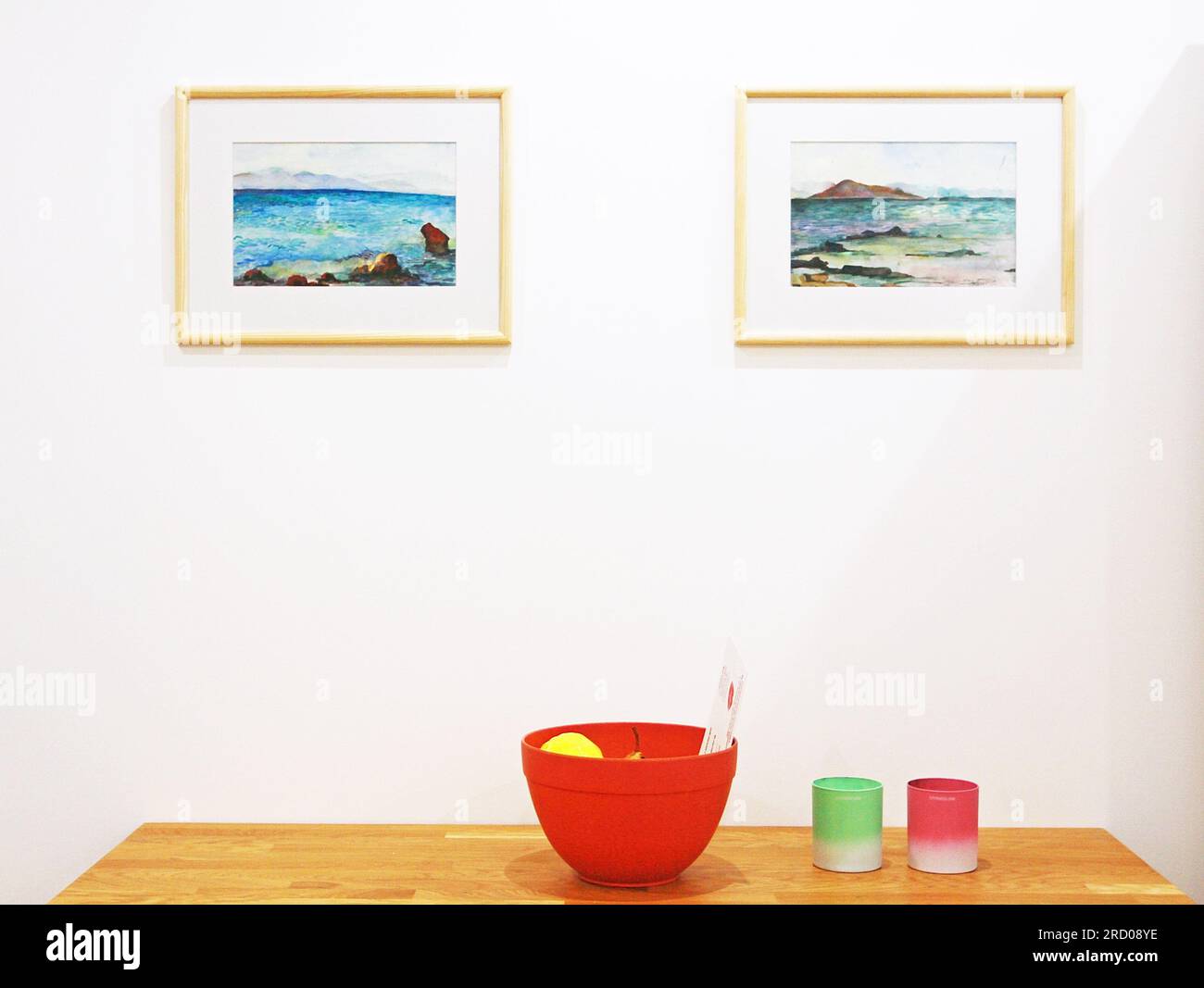 two watercolor paintings on the wall near a wooden kitchen table in the ...