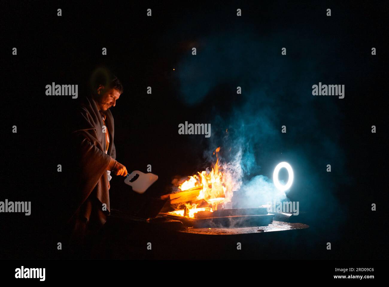 Man preparing bbq grill to cook on fire. Outside dark shot. Freeze ...