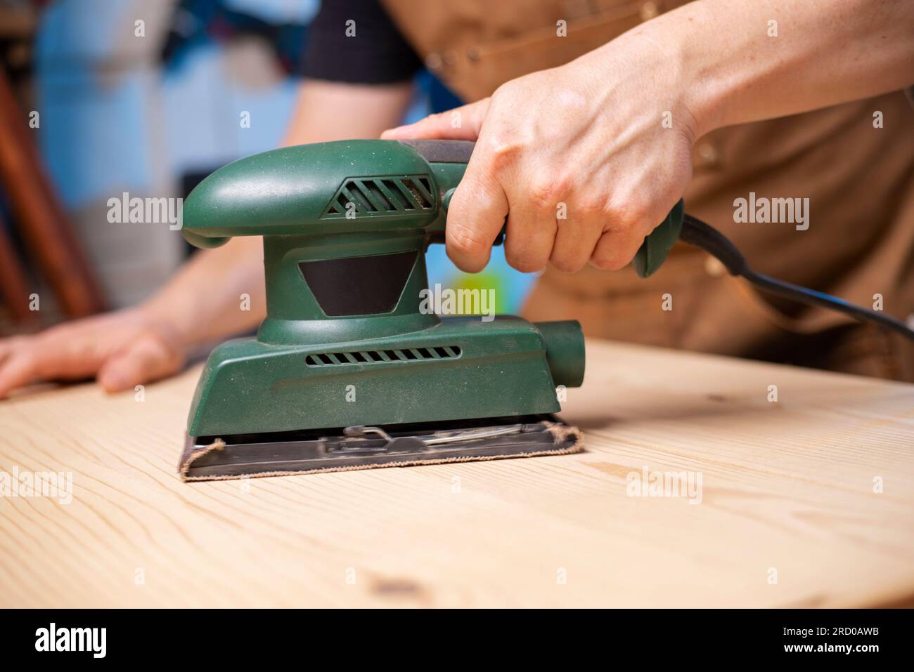 Closeup of carpenter sanding wooden planks with electrical sanding ...