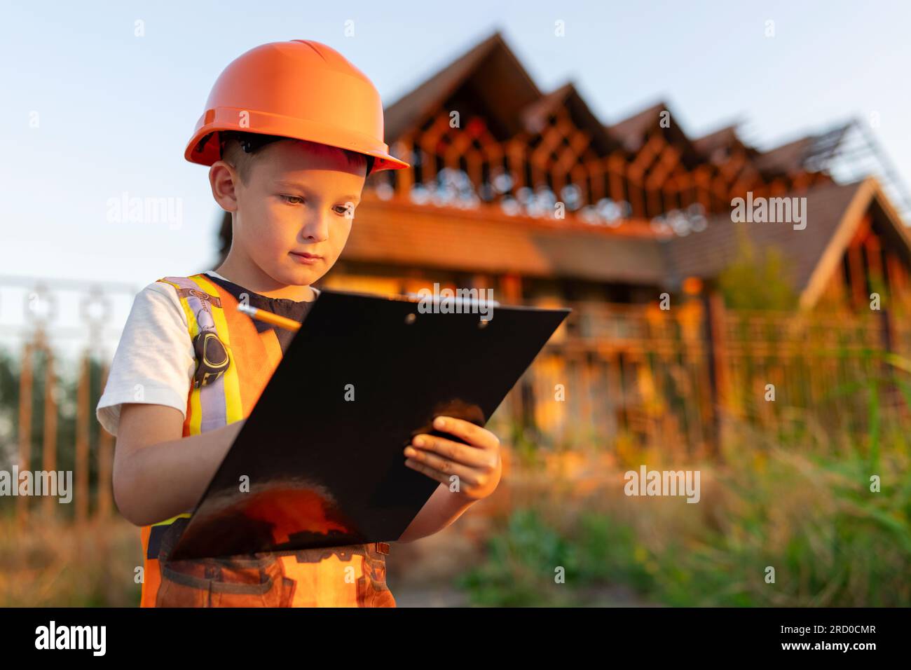 Child in a suit of an engineer is checking and inspecting the building ...