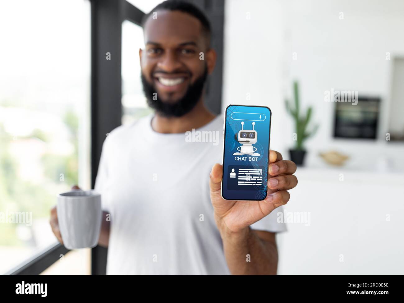 Cheerful black guy showing phone with chatbot screen Stock Photo - Alamy