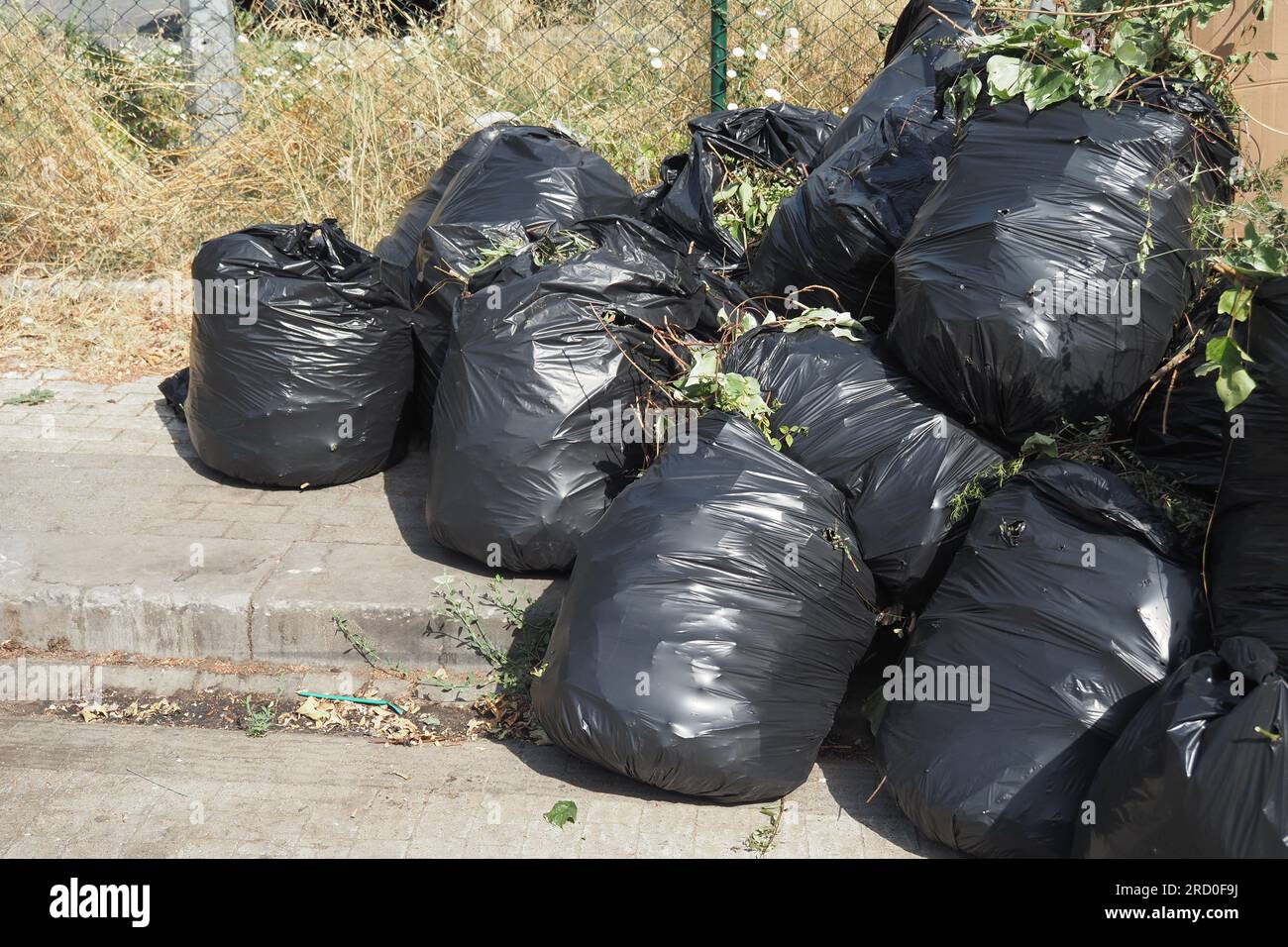 Black garbage bags stack on a park Stock Photo - Alamy