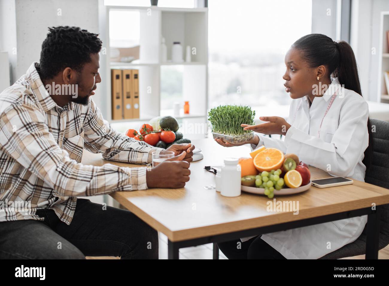 Attractive woman in lab coat giving consultation to adult man about ...