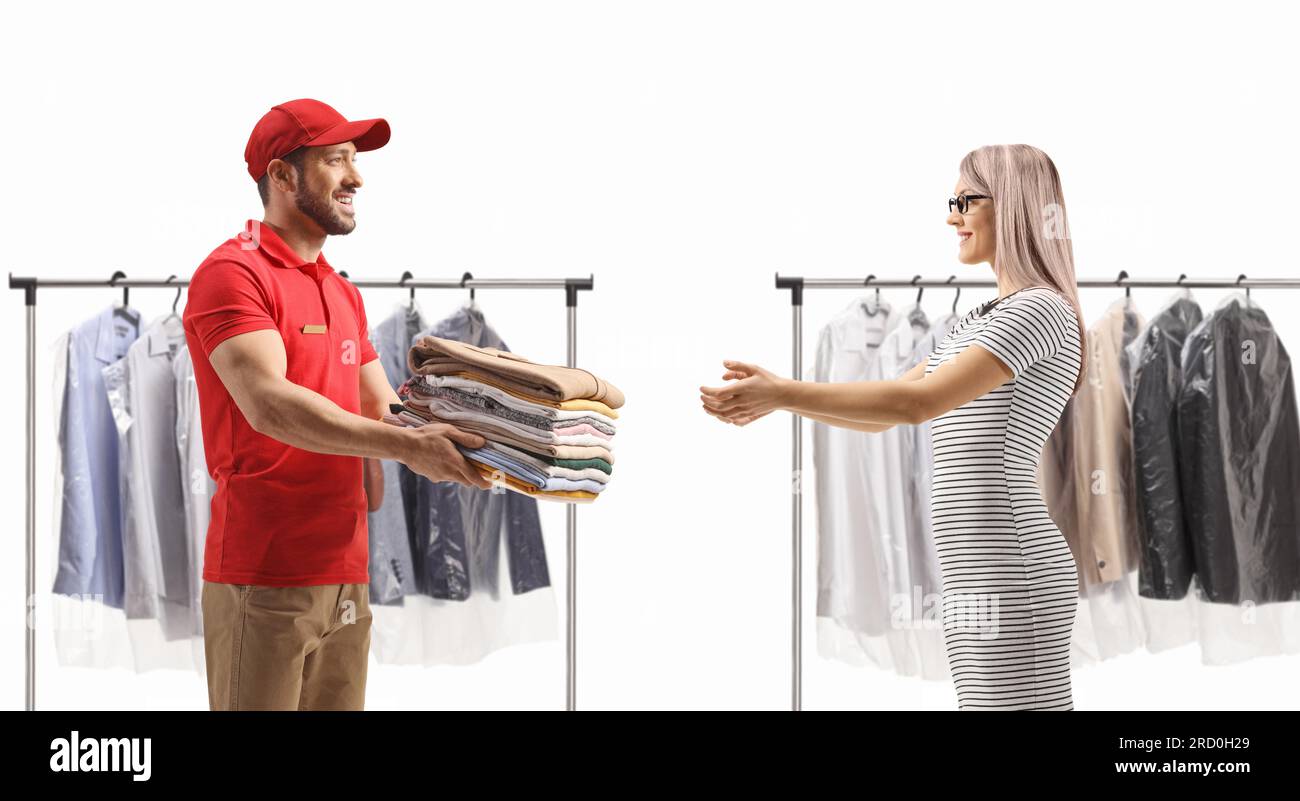 Man delivering a pile of folded clothes to a young woman at the dry ...