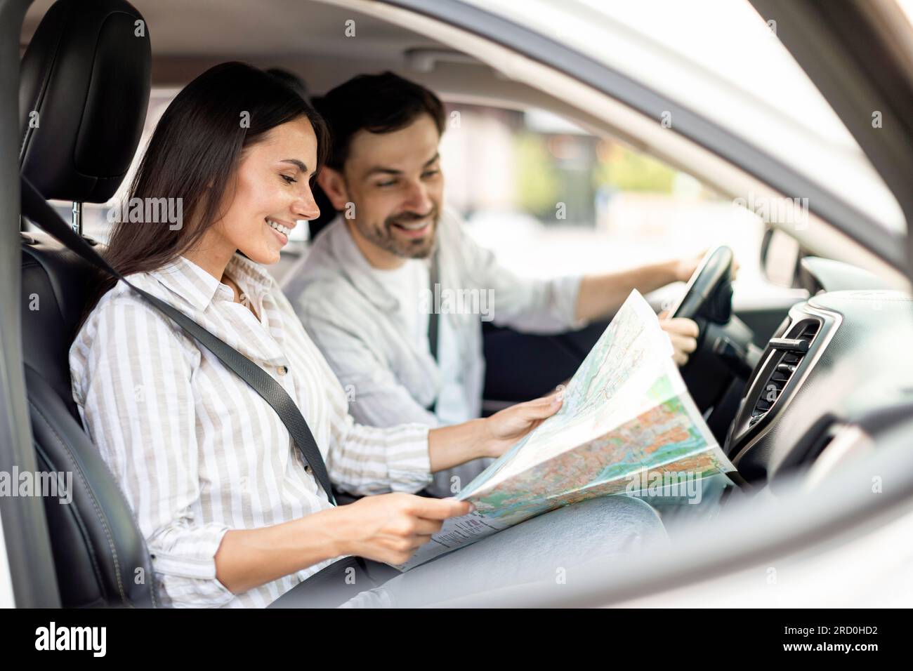 Travel concept. Happy couple using map in car Stock Photo - Alamy