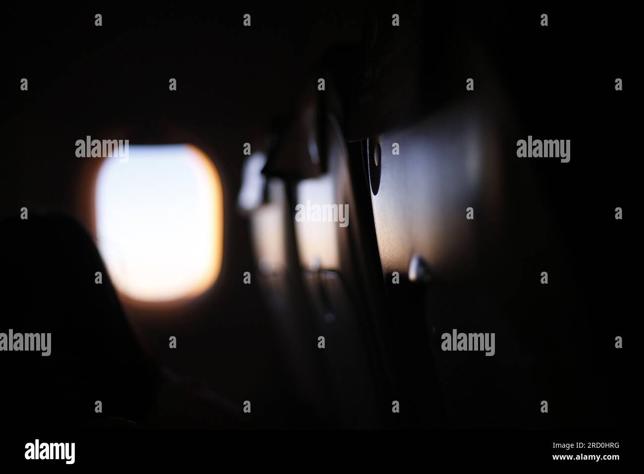 Commercial airplane window view of a blue sunrise sky and black ...