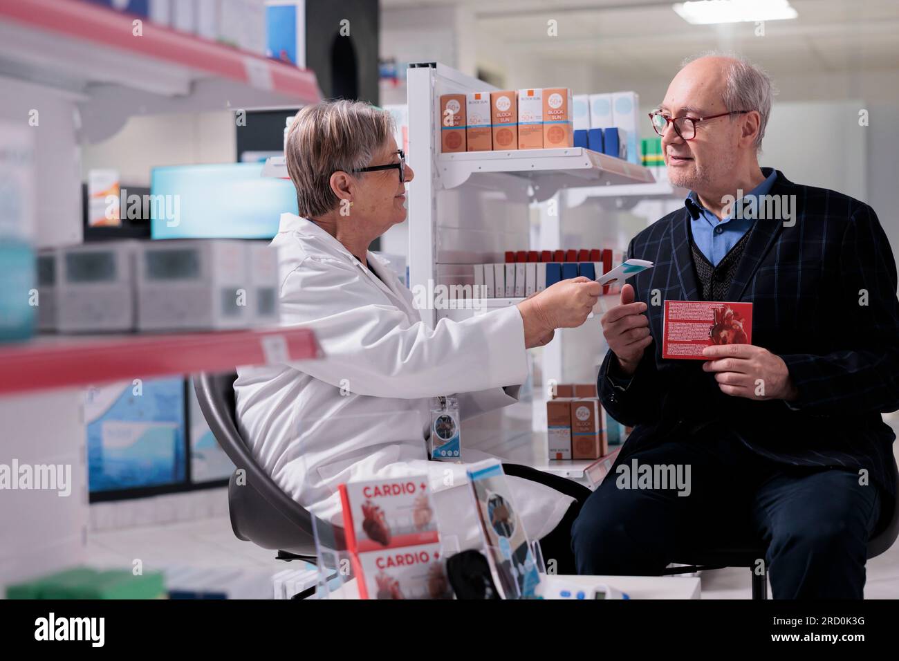 Senior drugstore client selecting heart health supplements in pharmacy ...