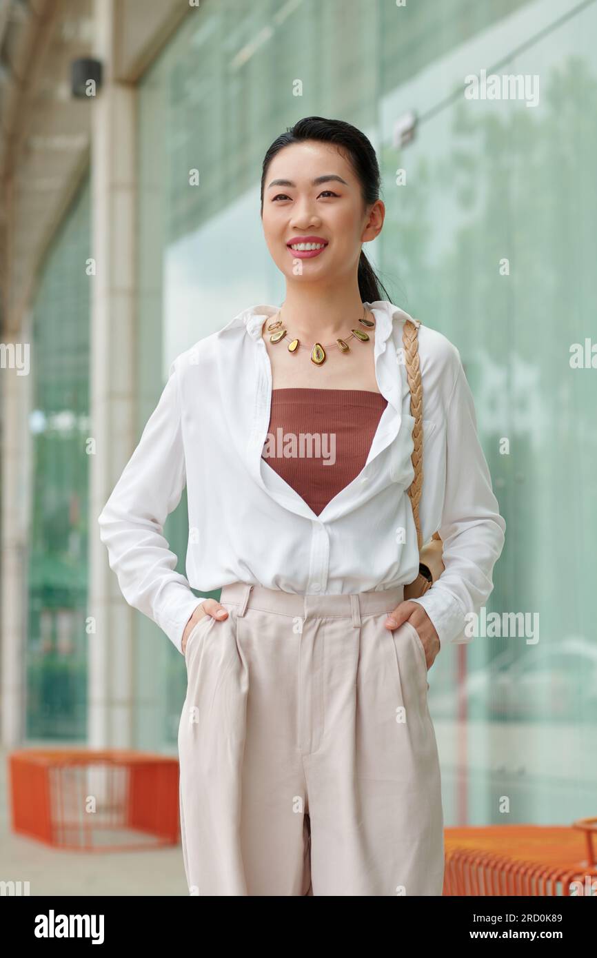 Portrait of smiling elegant business lady standing outside office ...