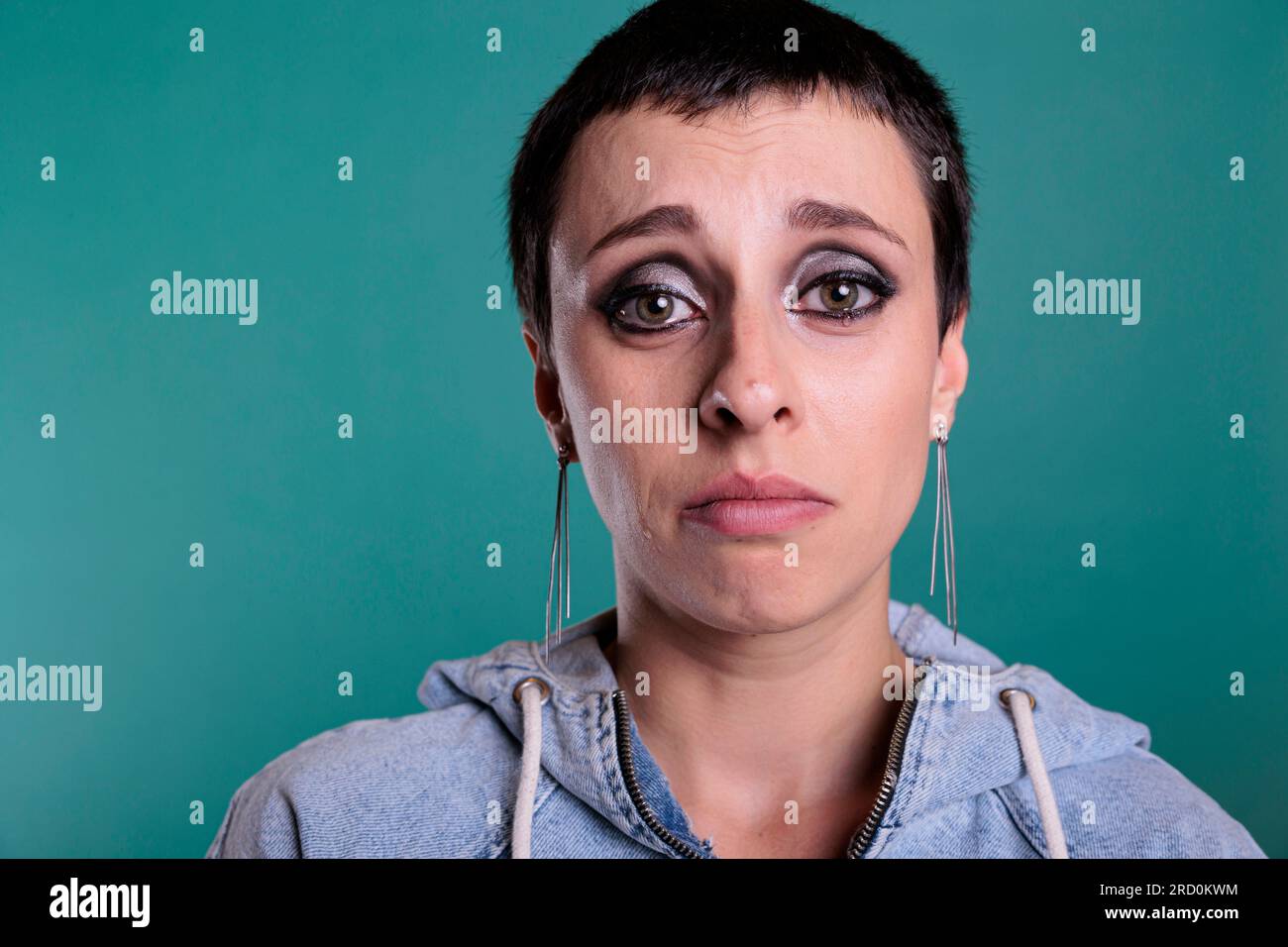 Upset unhappy woman crying after hearing of tragedy during studio shot ...