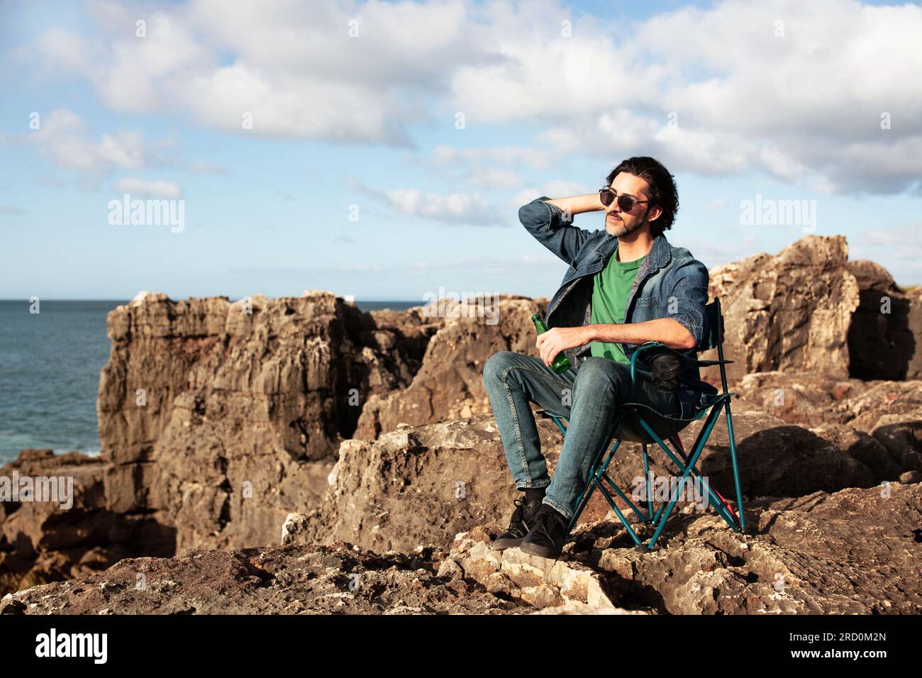 Handsome Young Man Sunbathing On The Beach Rocks Near Ocean Stock Photo ...
