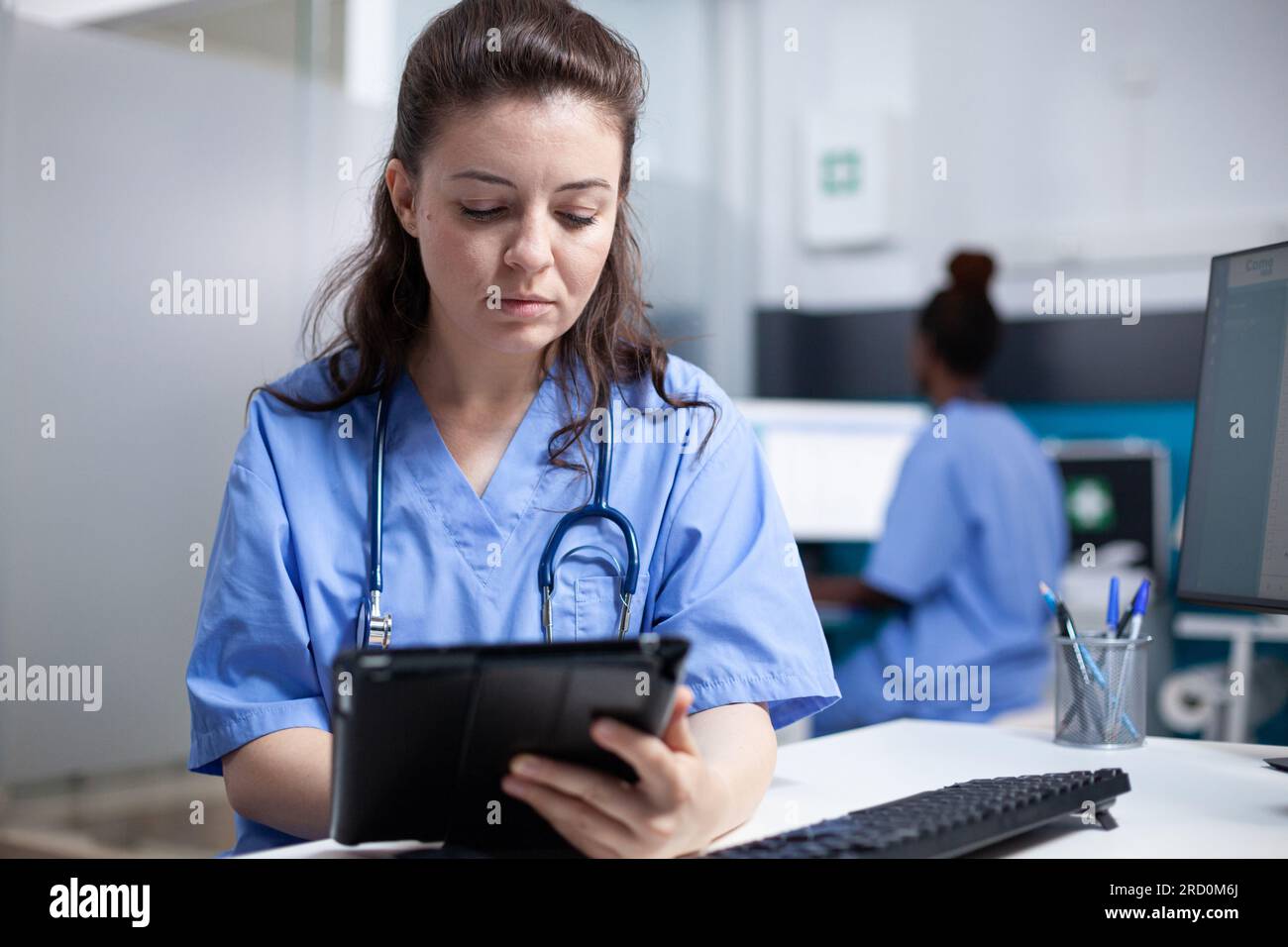 Nurse working on digital touchscreen tablet in professional healthcare ...