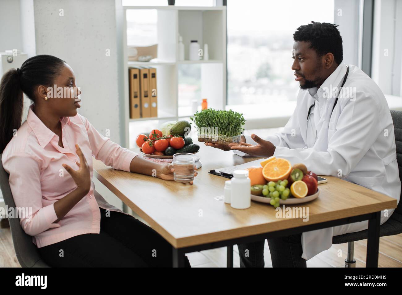 Focused middle-aged man reaching out microgreens in container while ...