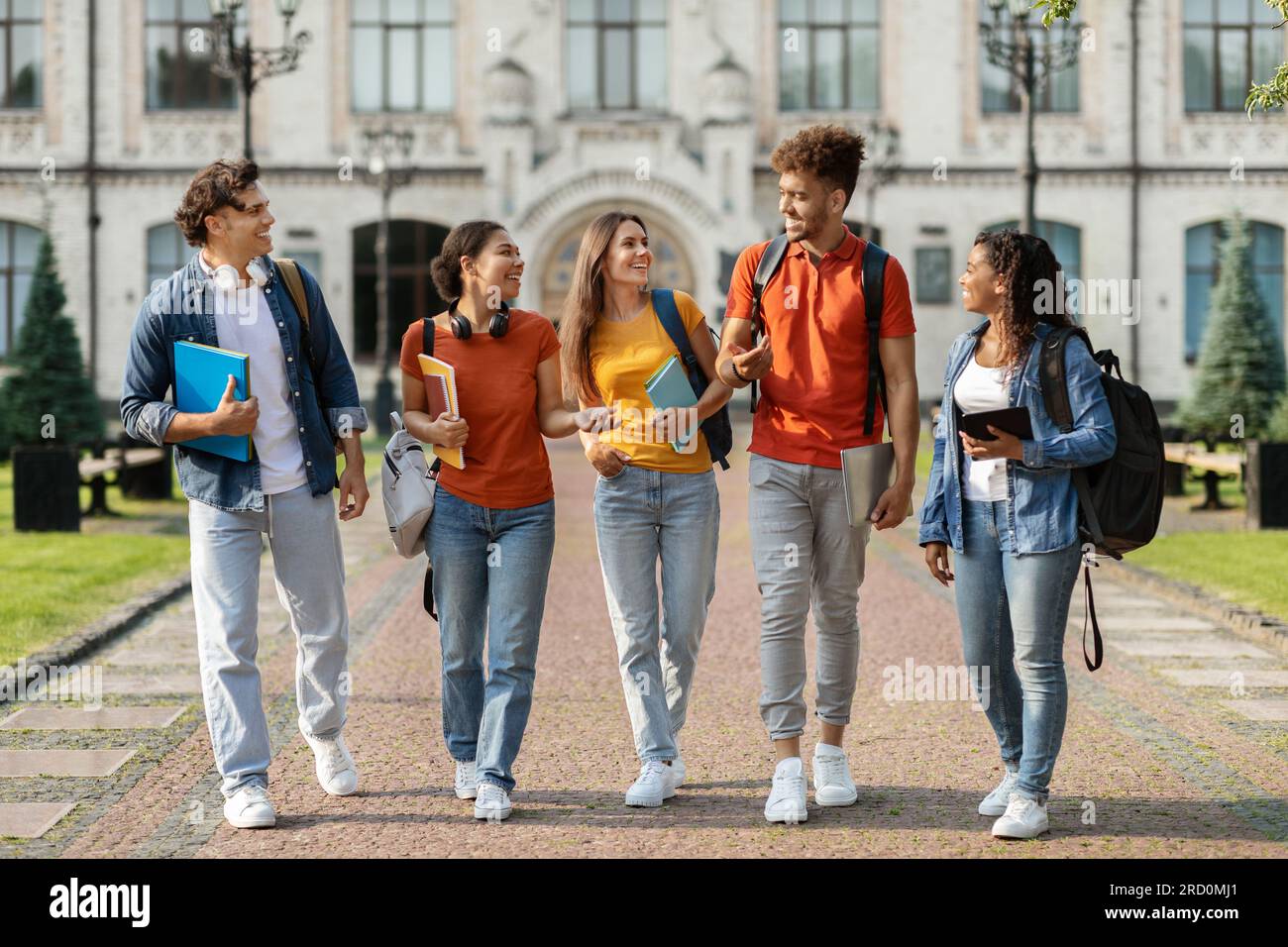 Happy university students walking together on campus, chatting and laughing Stock Photo - Alamy