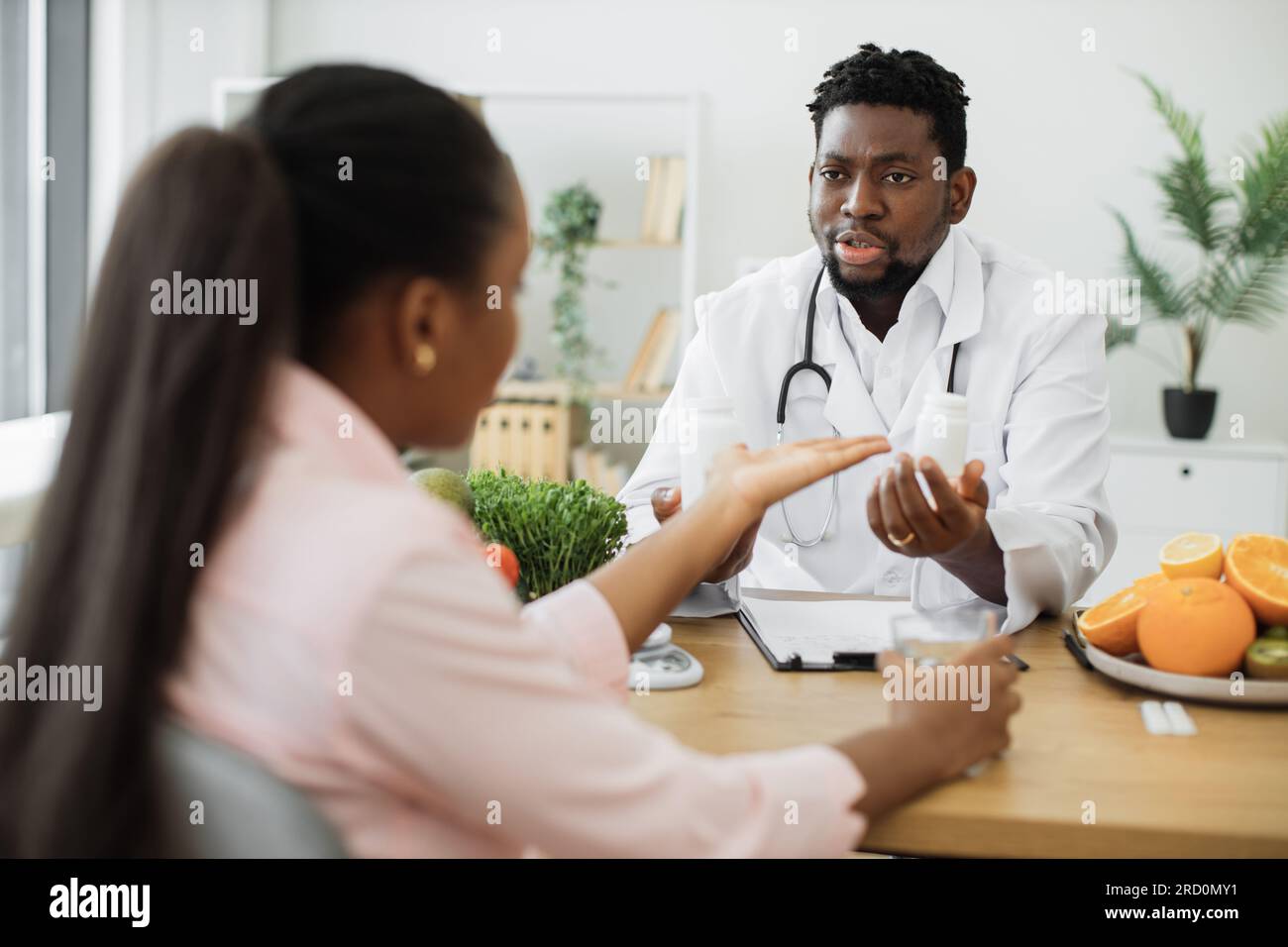 Crop of caring doctor wearing white lab coat and stethoscope giving ...