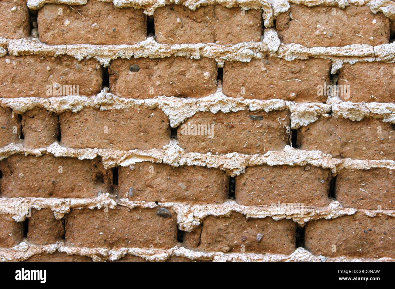 Old adobe wall is composed of layers of adobe bricks cemented together ...
