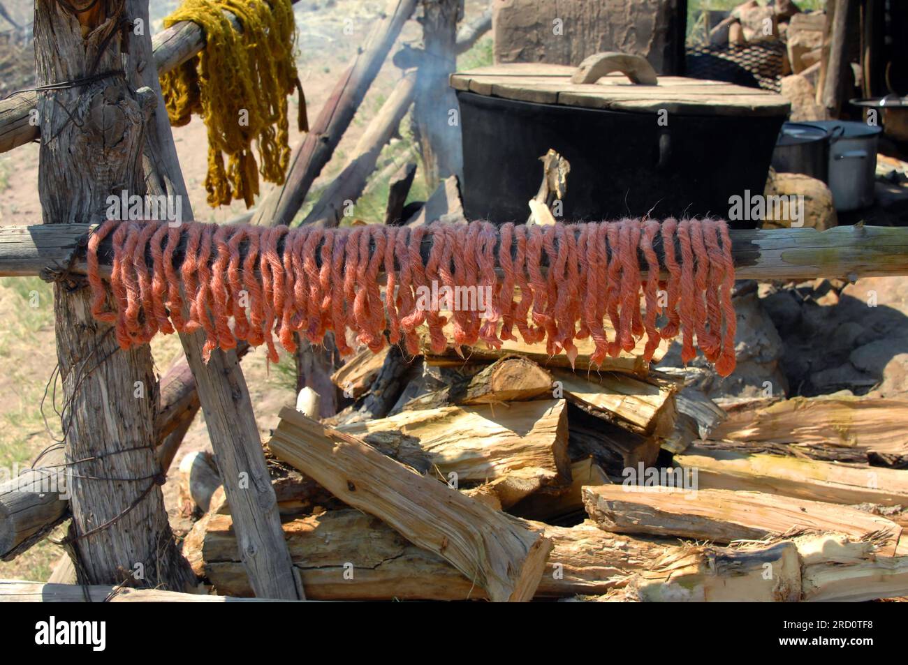 Large pieces of wool yarn lay across an old fence railing. They are ...