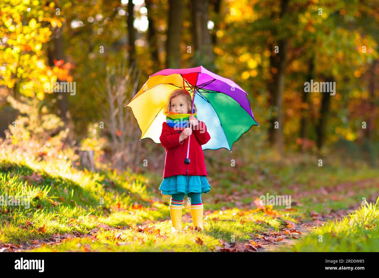 Kid playing out in the rain. Children with umbrella and rain boots play ...