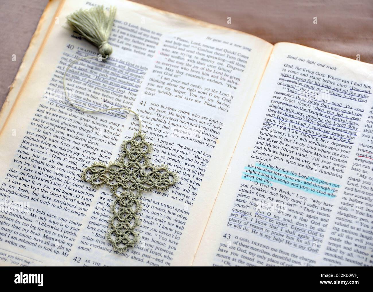 Hand crocheted bookmark lays on open Bible. Underlined passages show ...