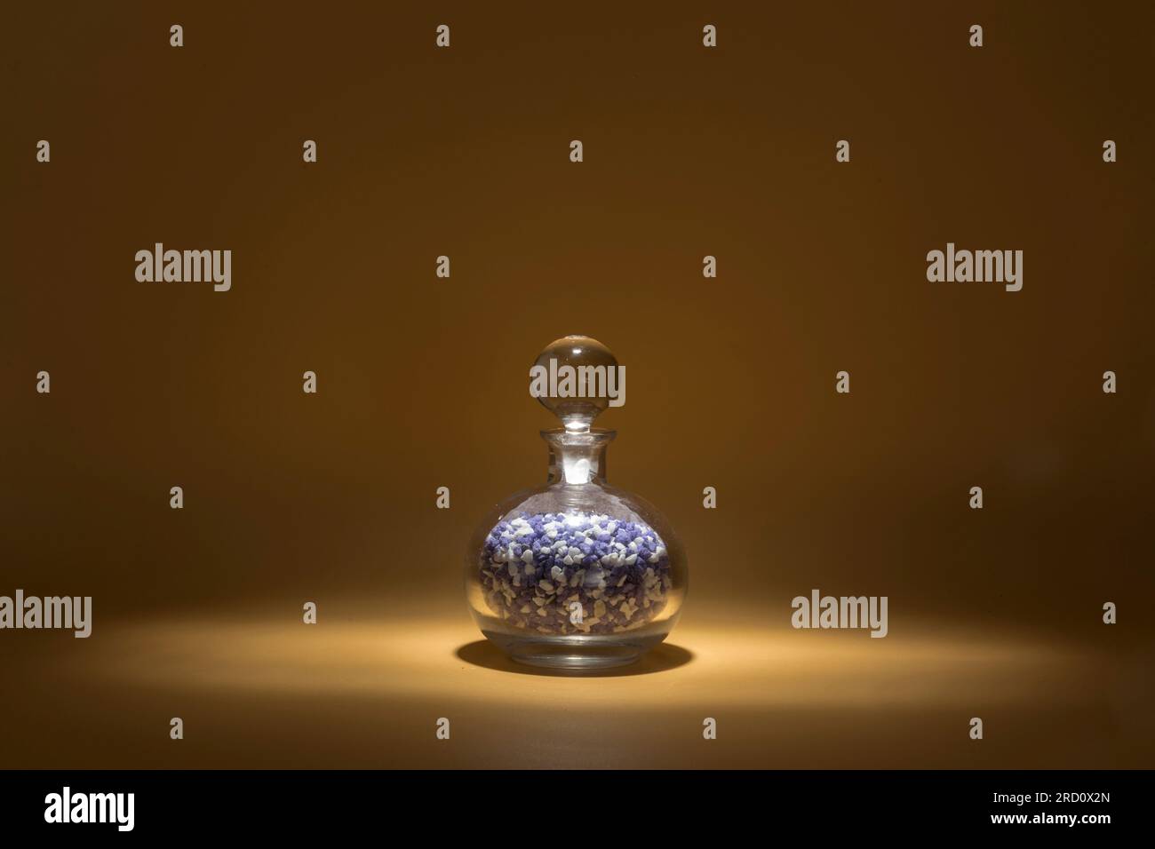 glass bath salt bottle, which has round shapes and is filled with blue ...