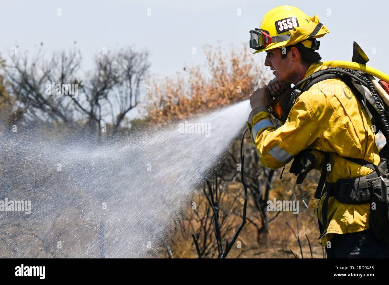 A Riverside firefighter sprays down the ground hot spots on Monday ...
