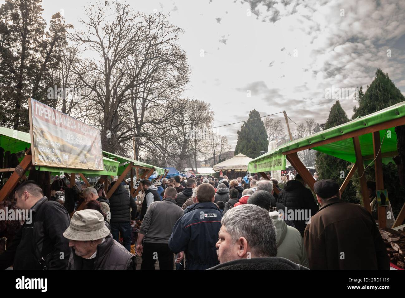 Picture of a crowd of people passing by stands and stalls in the ...