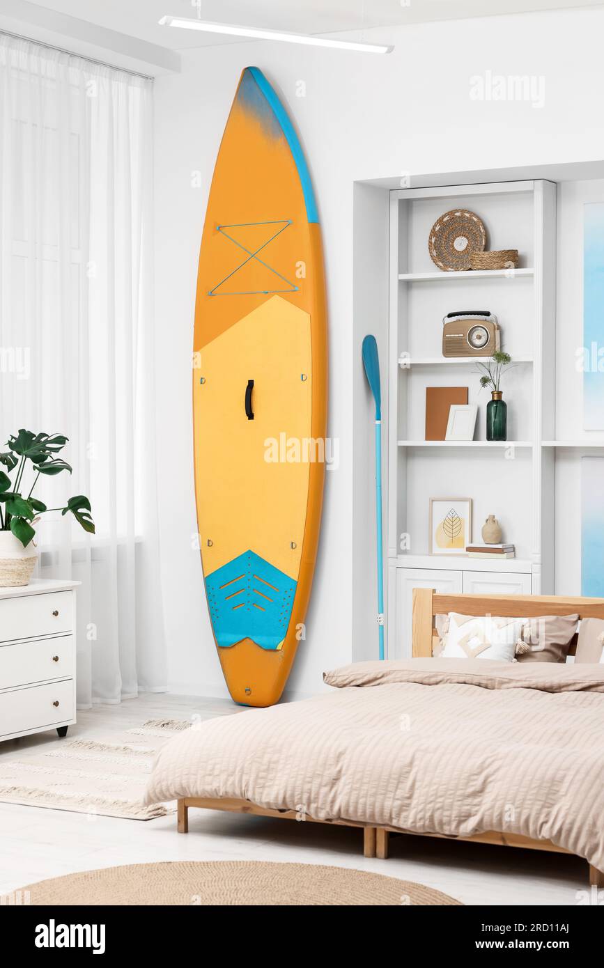 SUP board, bed and furniture in room. Interior design Stock Photo - Alamy