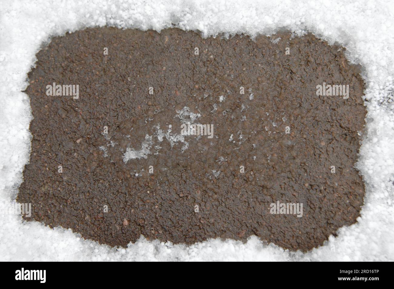 Frame shows a background edging of snow. Center is wet pavement Stock ...