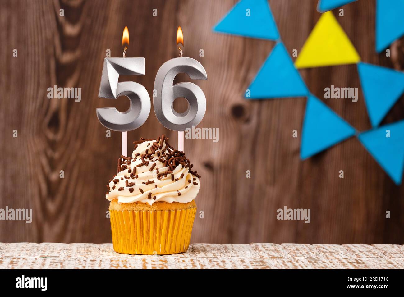 burning candle - birthday number 56 on wooden background with pennants ...