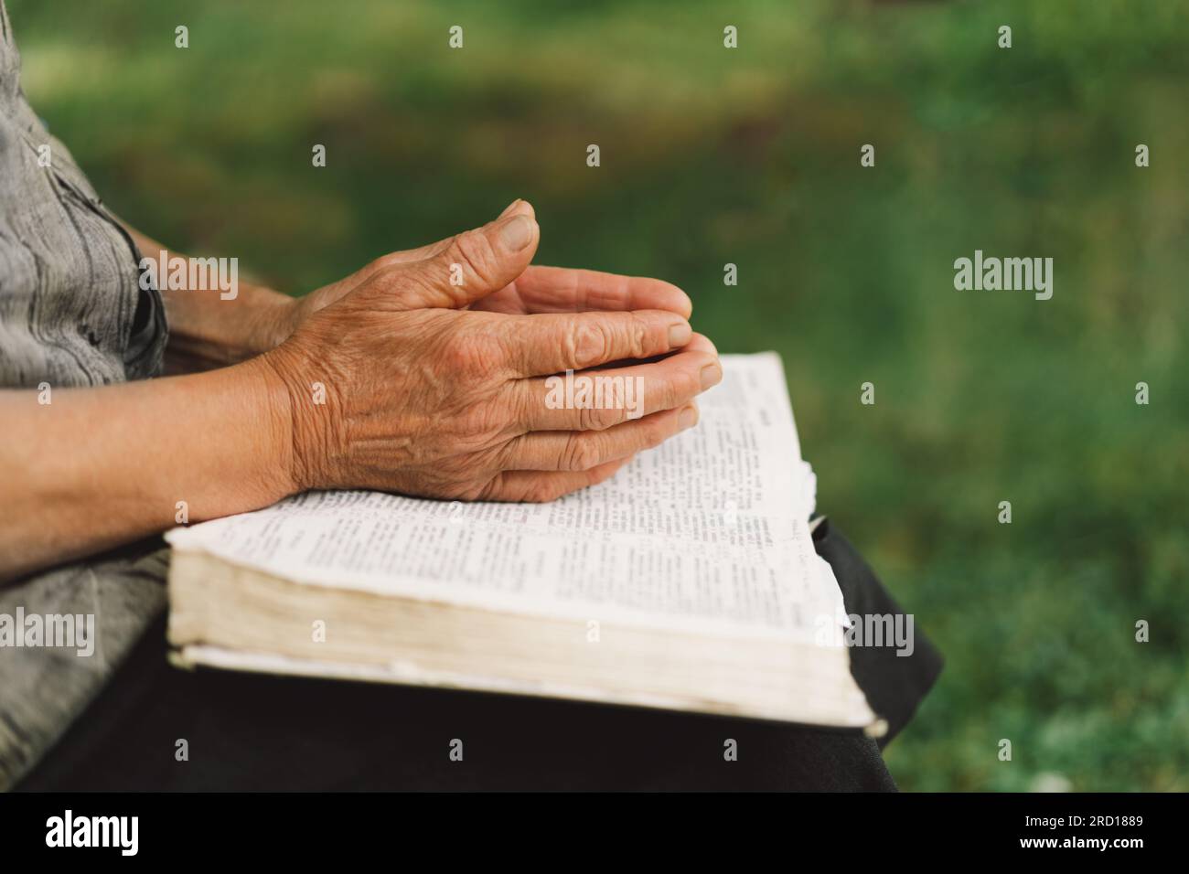 Old woman praying for hope or reading holy bible Stock Photo - Alamy