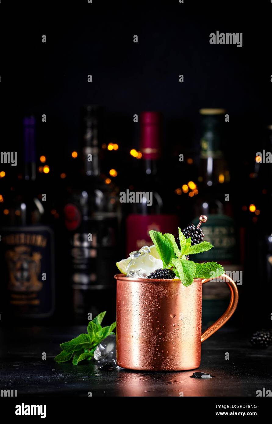 Blackberry Moscow mule alcoholic cocktail drink in copper mug with lime ...