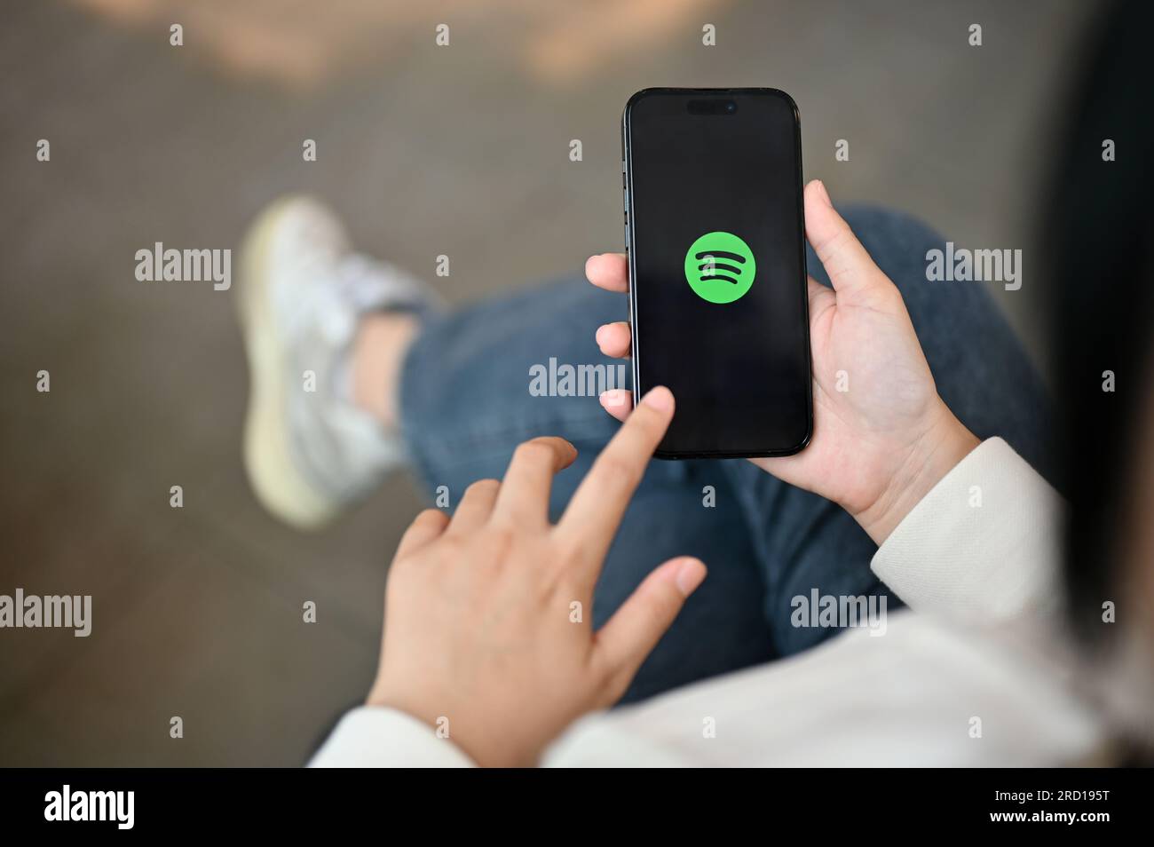 Chiang Mai, Thailand - July 17 2023: An Asian woman using Spotify ...