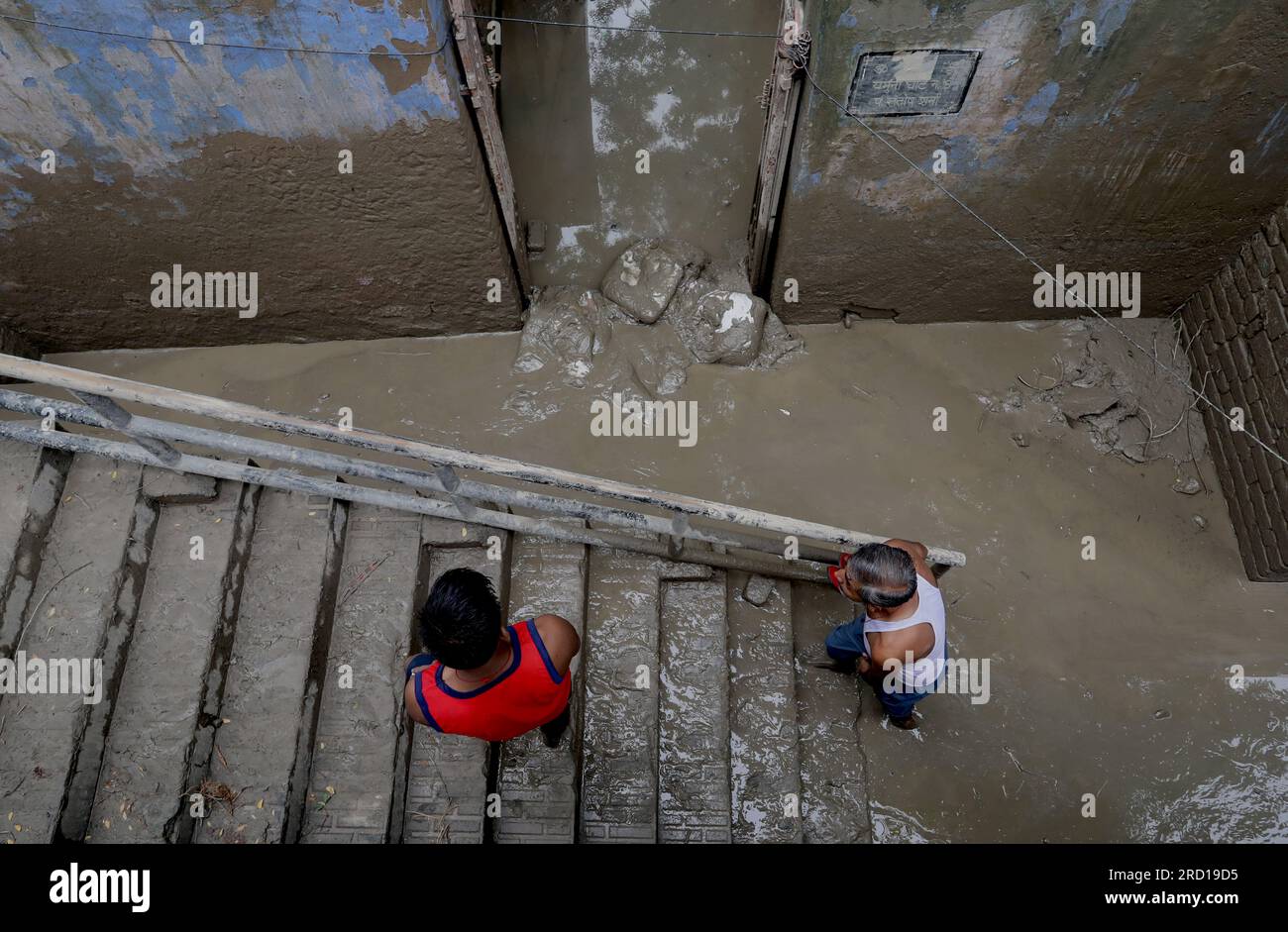 Residents wade through the muddy stair as floodwater of the swollen ...