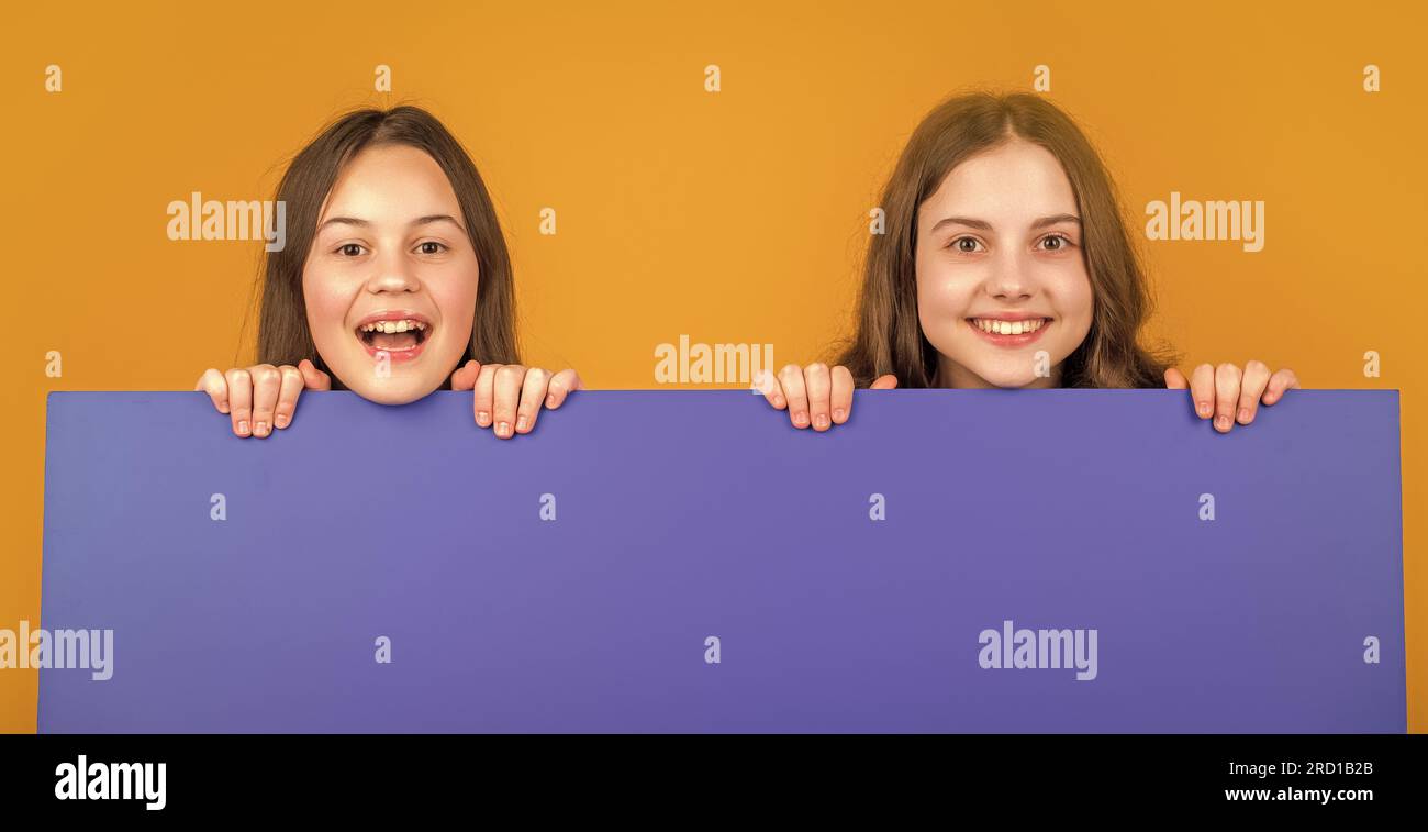 happy children behind blank blue paper with copy space for ...