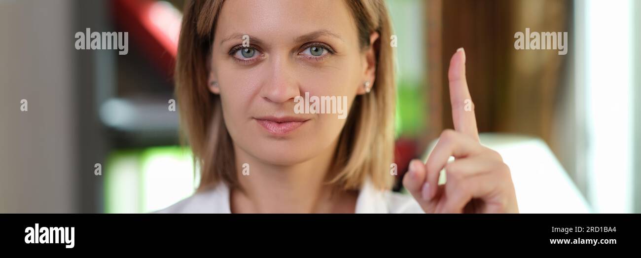 Female doctor pointing her finger up in medical office Stock Photo - Alamy