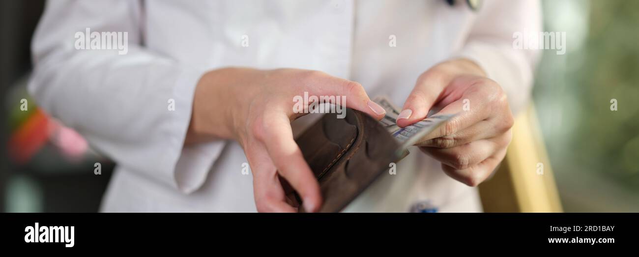 Female doctor counting money in her wallet close up Stock Photo - Alamy