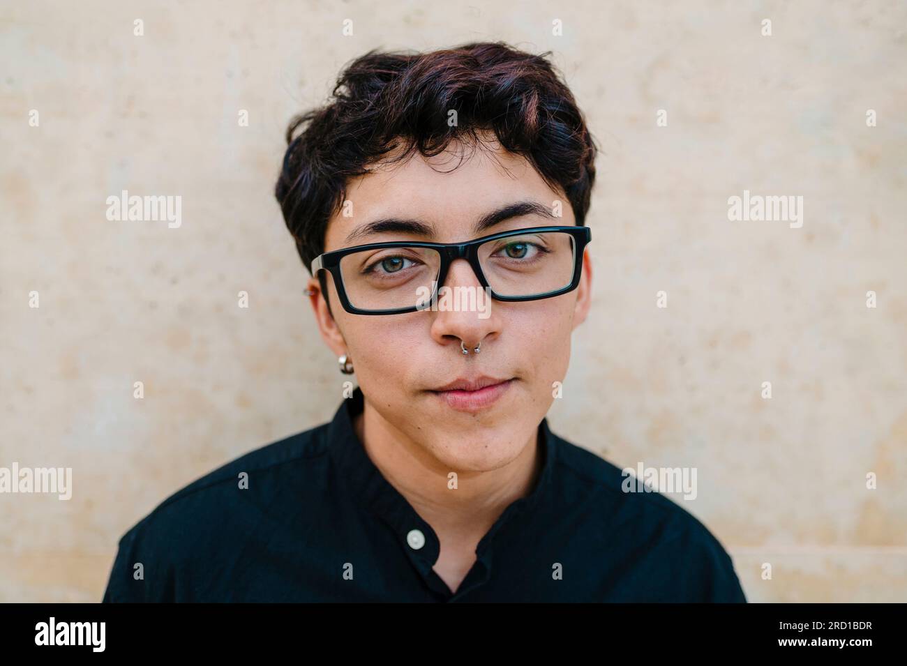 Close up view of a young transgender man looking at camera and smiling ...