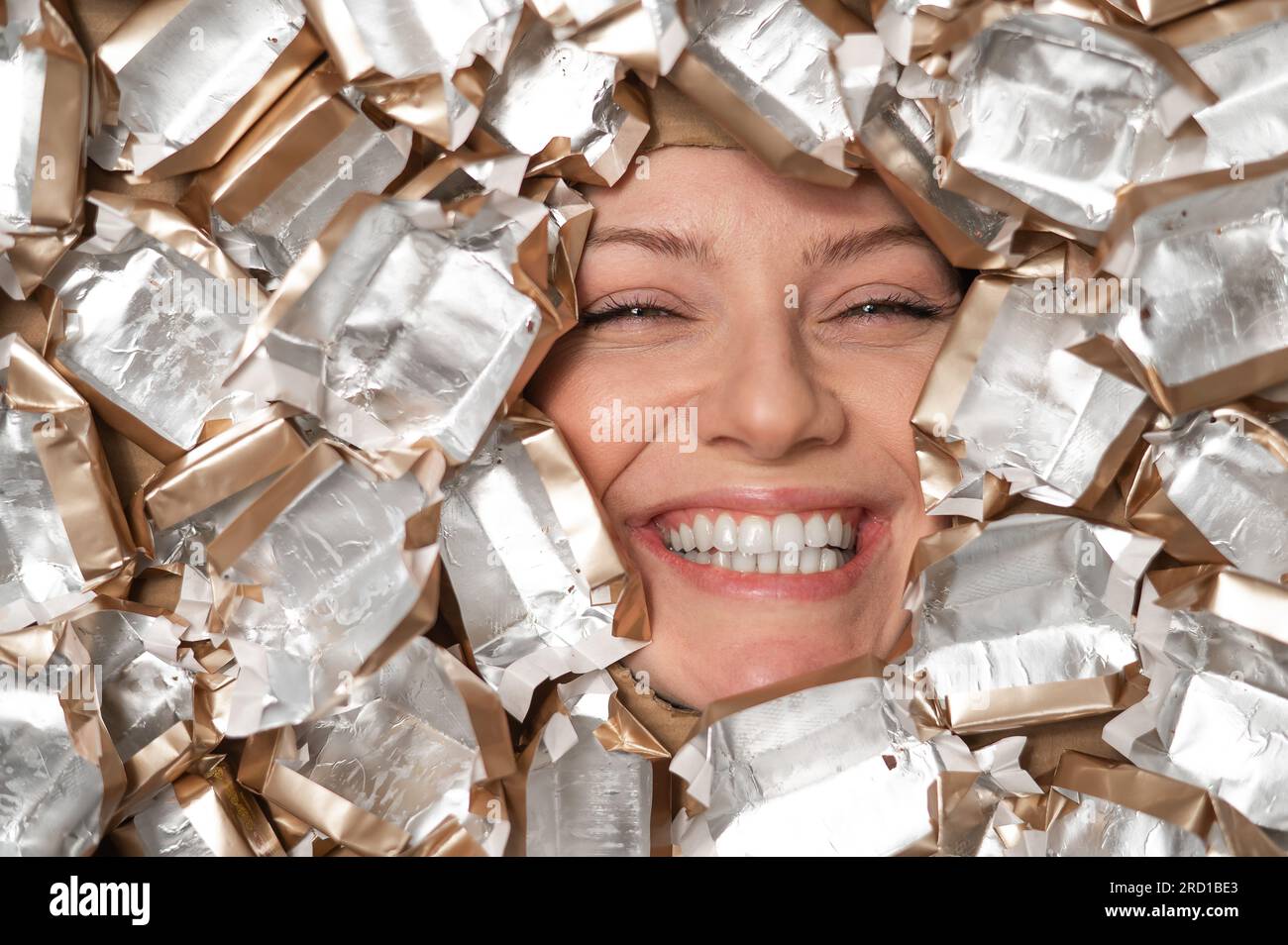 The face of a Caucasian woman surrounded by candy wrappers Stock Photo ...