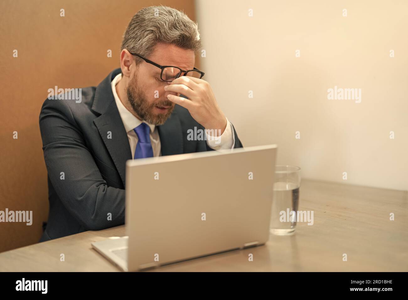tired overworked businessman has headache while working. overworked ...