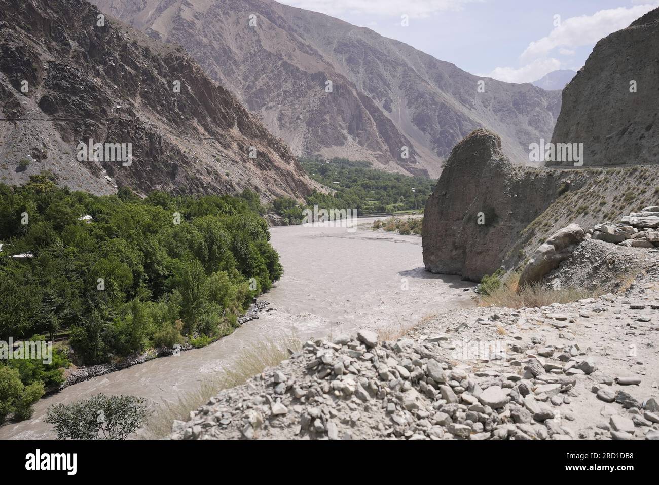 A stream coursing through the barren mountains and a patch of green ...
