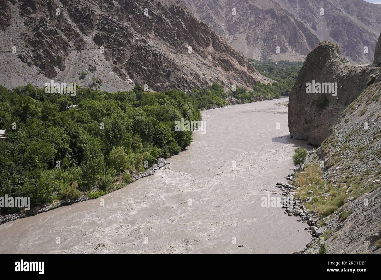 A stream coursing through the barren mountains and a patch of green ...
