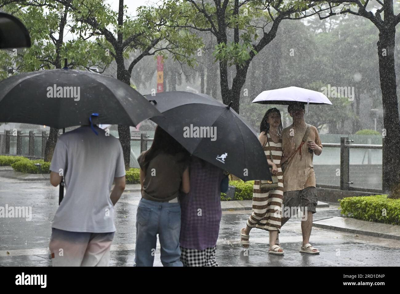 **CHINESE MAINLAND, HONG KONG, MACAU AND TAIWAN OUT** Local residents walk in rain and wind as ...