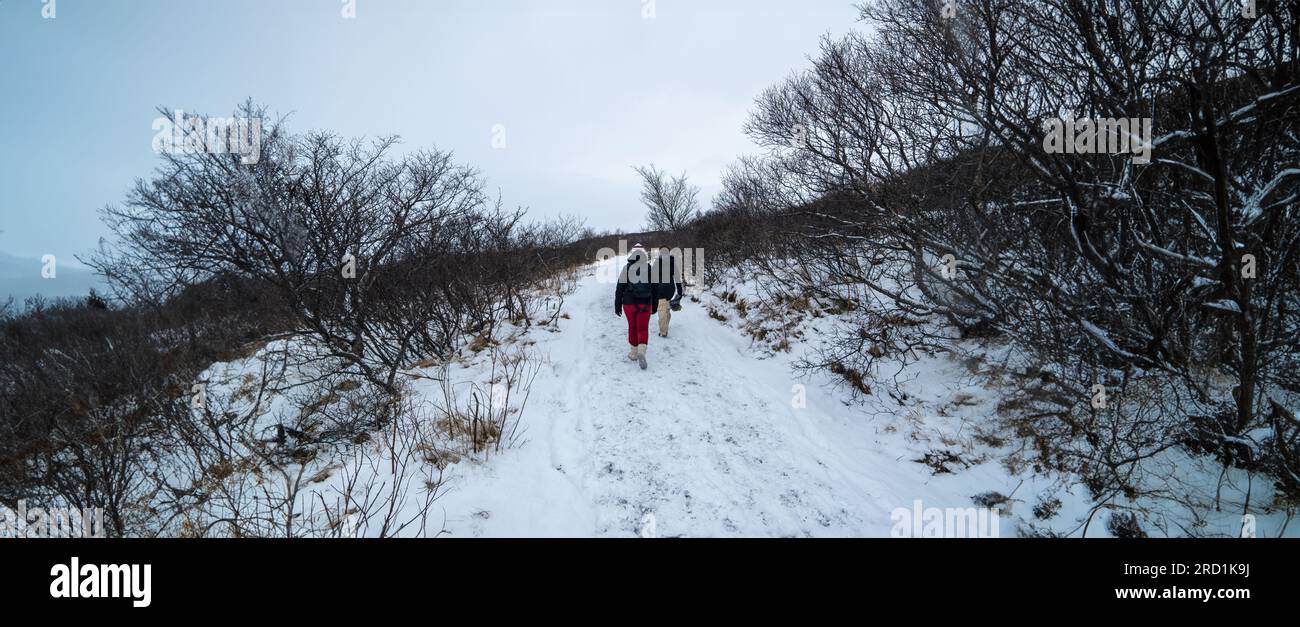 Two women bundled up for the extreme cold walking on a snowy path with ...