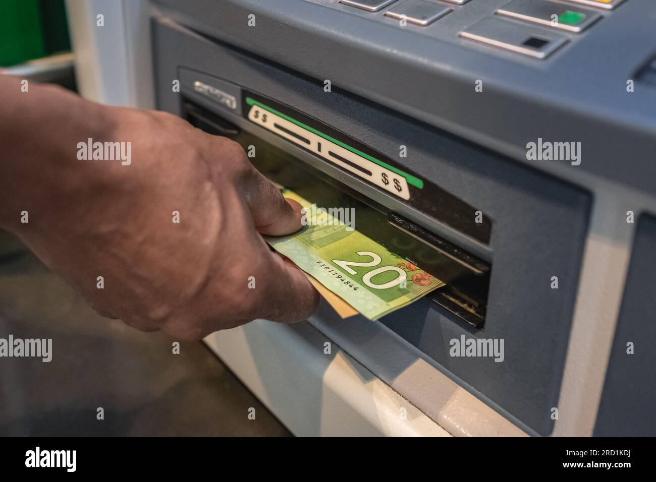 Cash withdrawal at an ATM. Money in the hands of close-up. Canadian ...