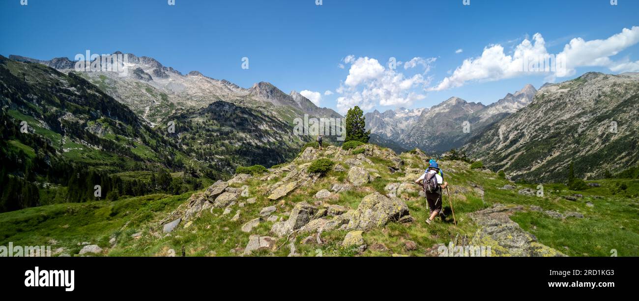 Woman hiker on top of a mountain and two people approaching watching ...