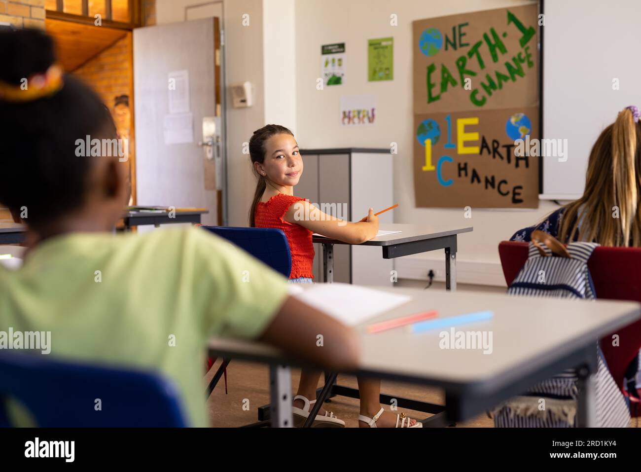 Portrait of happy caucasian schoolgirl in diverse elementary school ...