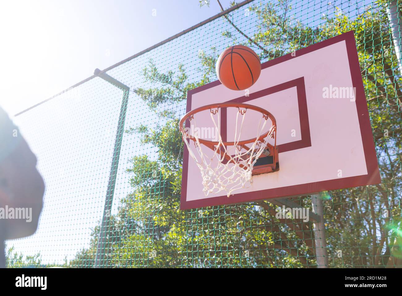Biracial female basketball player shooting basketball at basketball ...