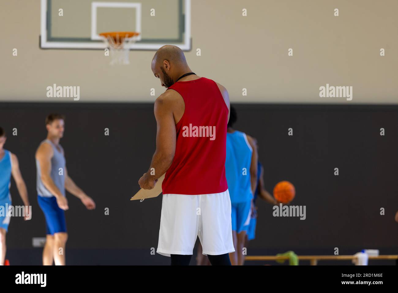 Diverse male basketball players wearing blue sports clothes and playing ...