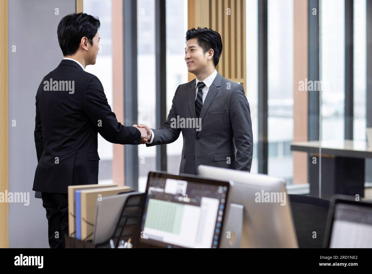 Successful Chinese business people shaking hands in office Stock Photo ...